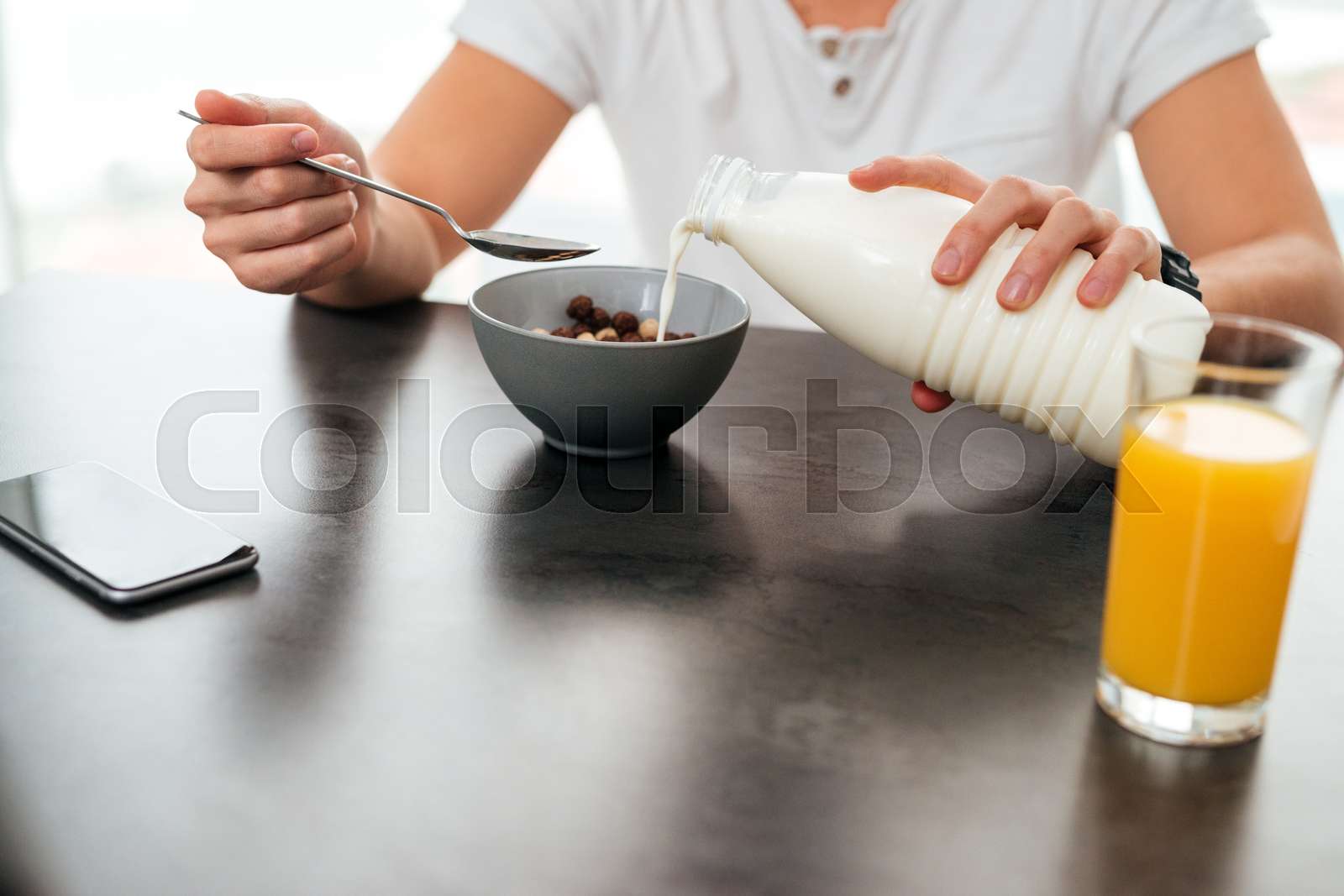 Asian man by the table with milk | Stock image | Colourbox