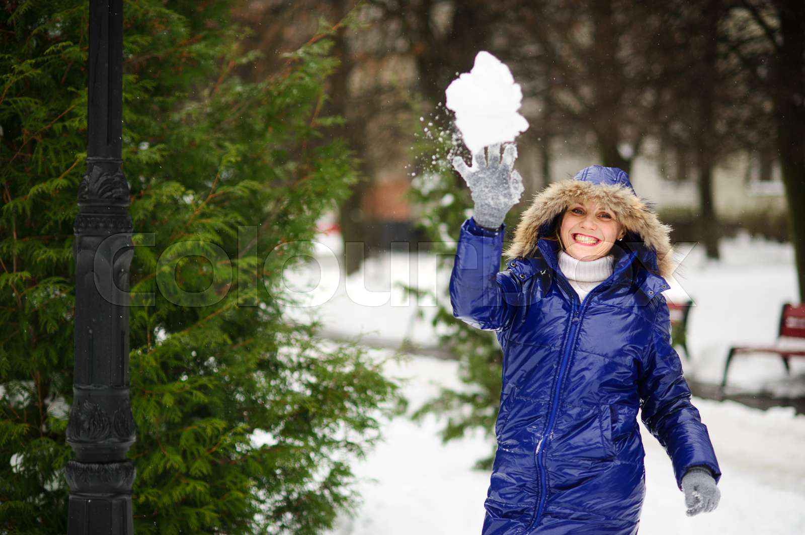 Cute girl throws snowball. | Stock image | Colourbox