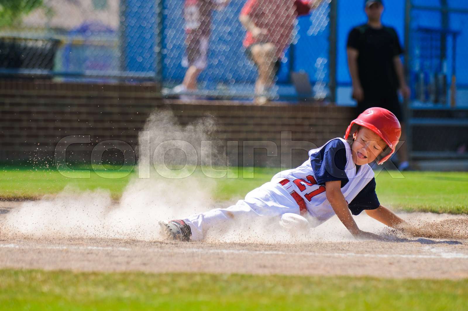 Little league baseball player sliding home. | Stock image | Colourbox