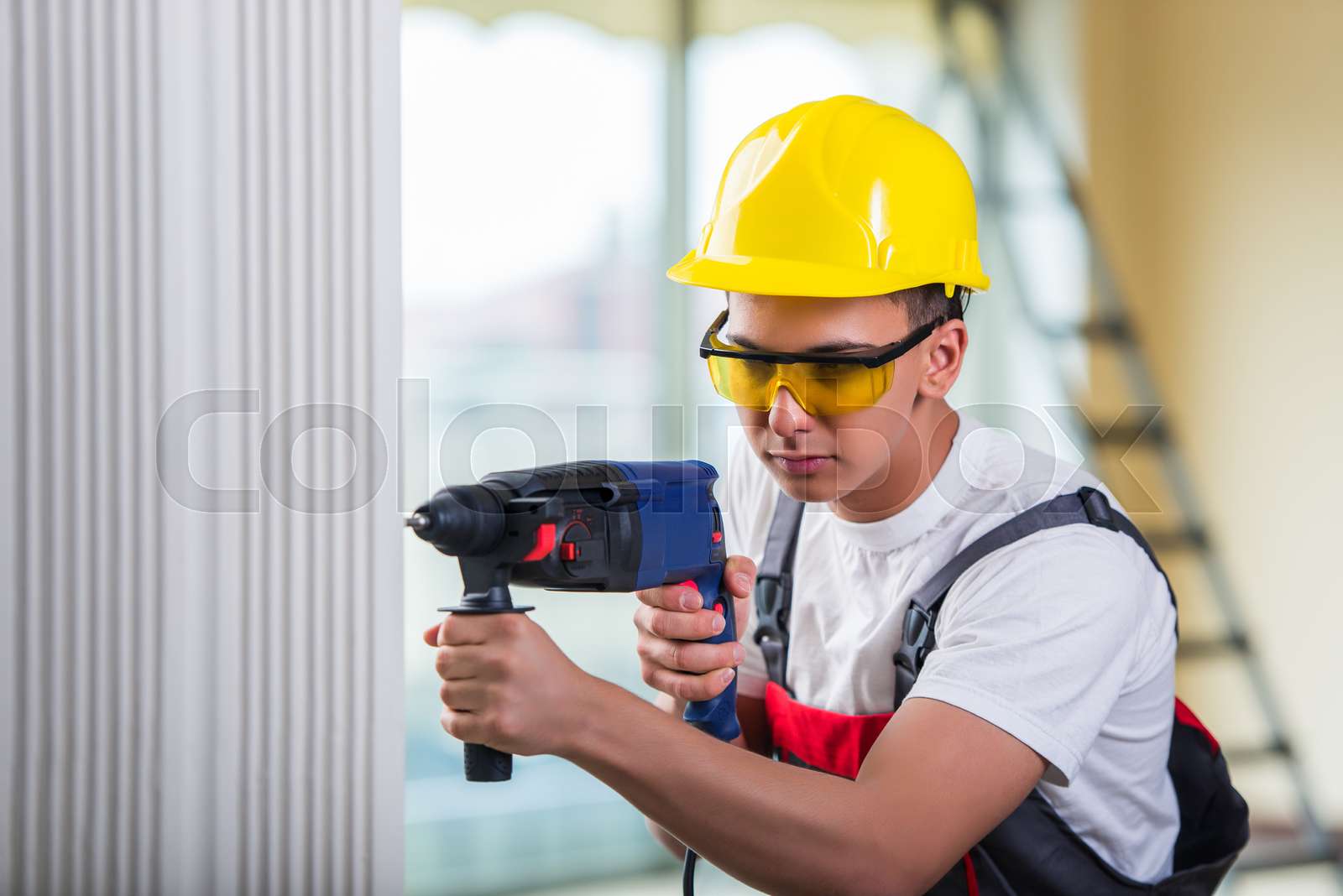 Man drilling the wall with drill perforator | Stock image | Colourbox