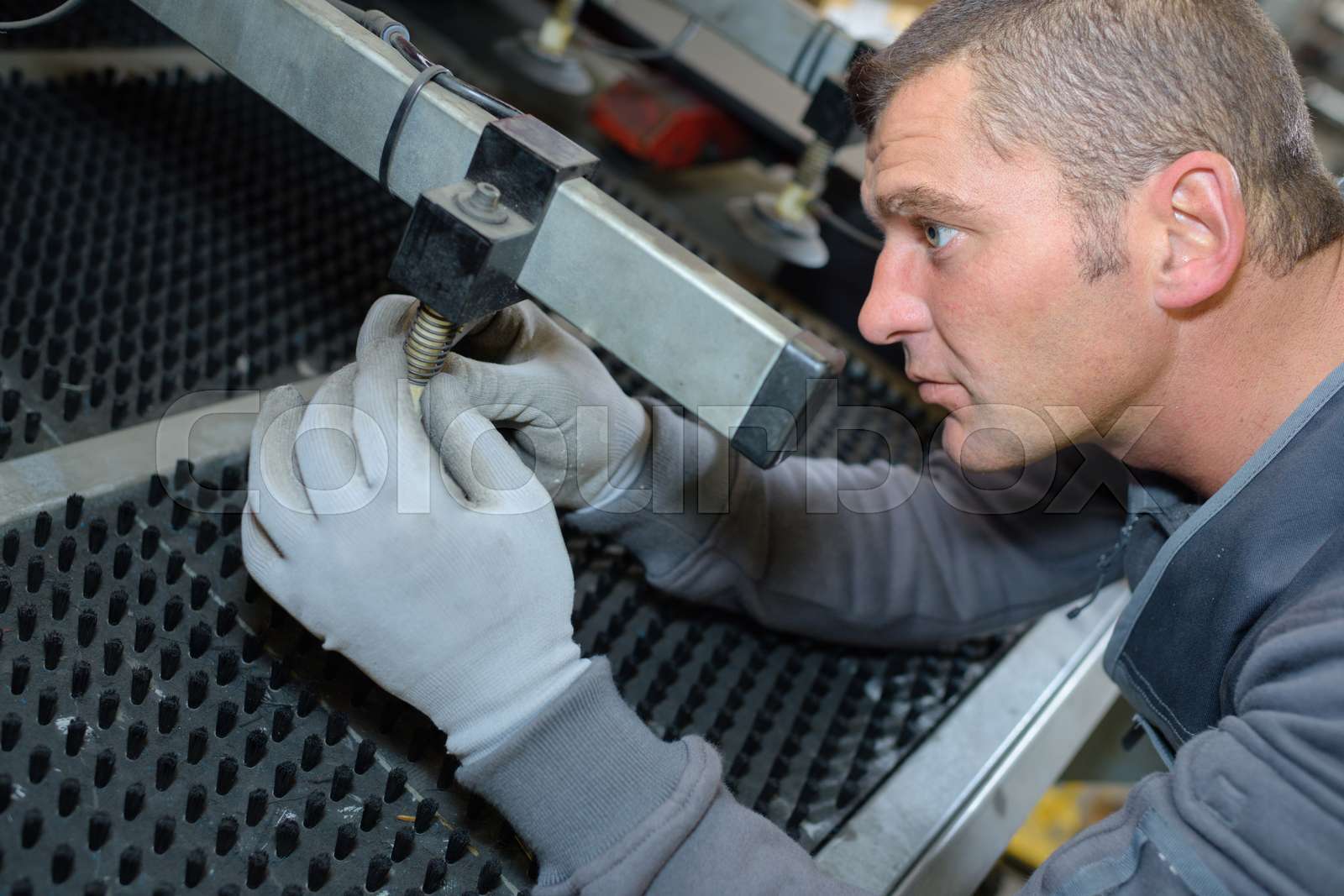 Man setting up industrial machine | Stock image | Colourbox