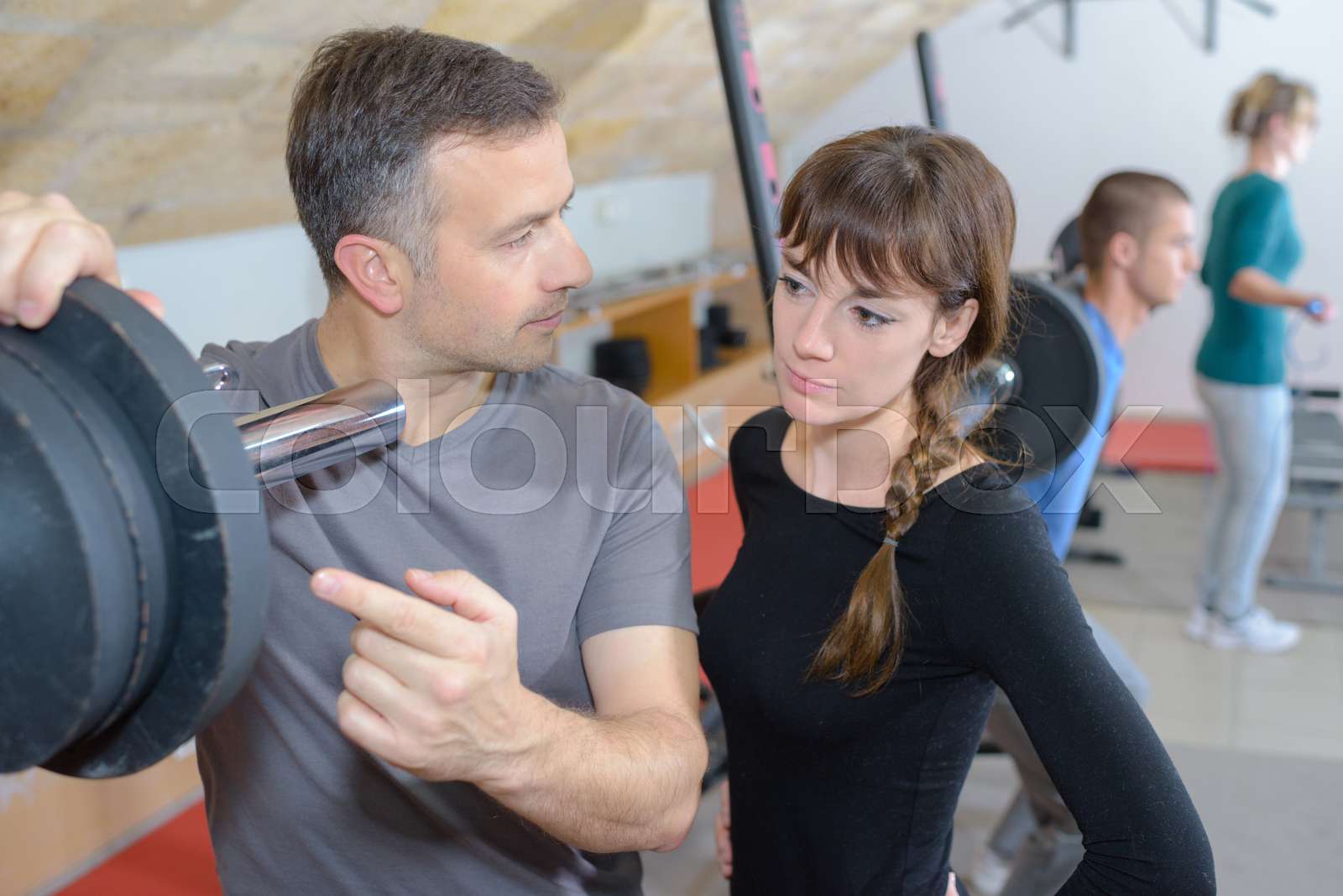 trainer explaining how to use training machine in a gym | Stock image ...