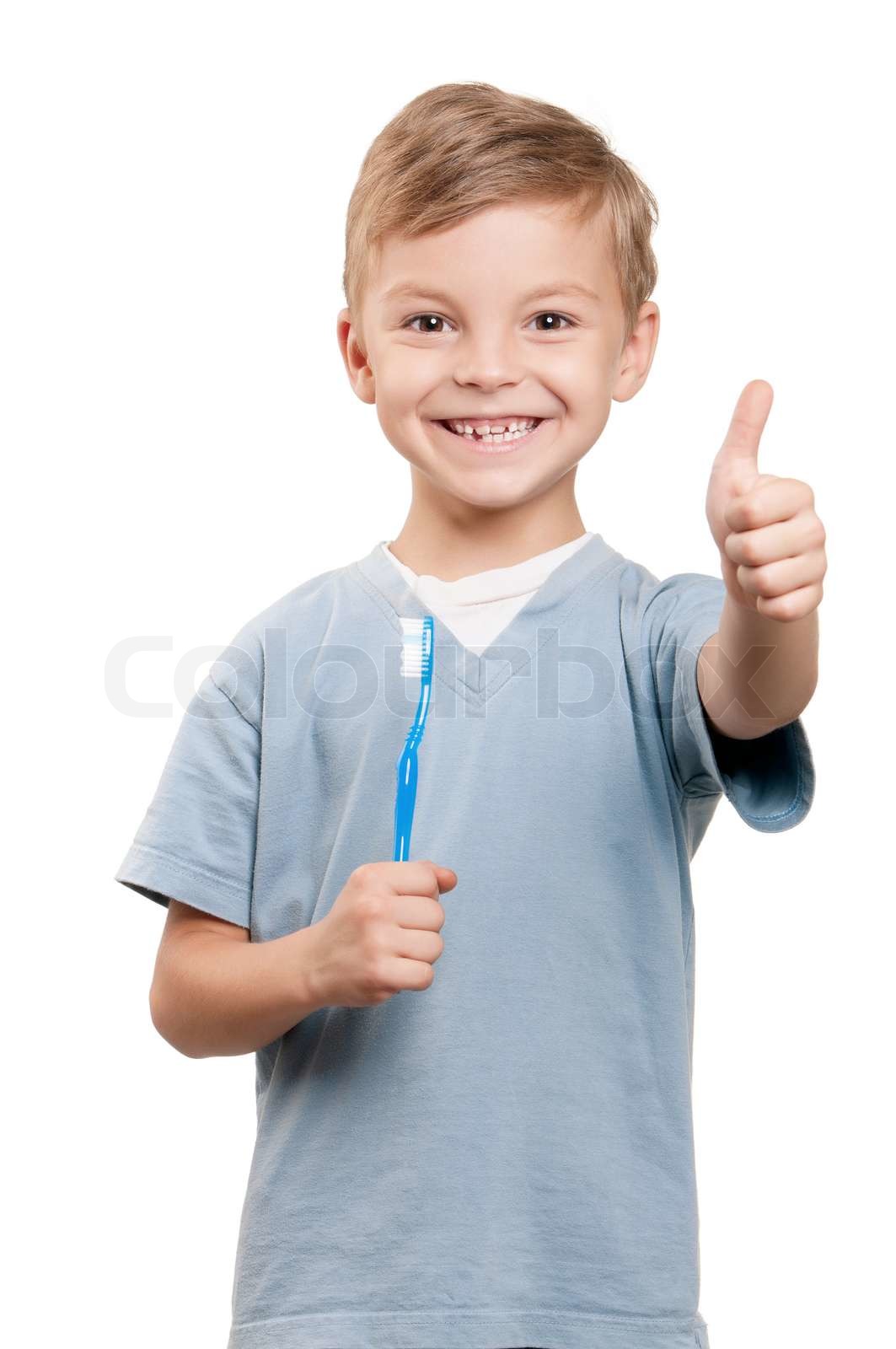 Portrait of a little boy holding a tooth brush over white background ...