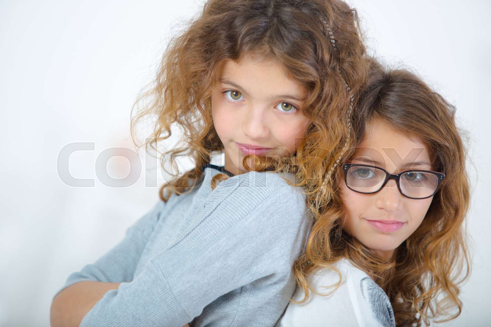 Two young girls stood back to back | Stock image | Colourbox