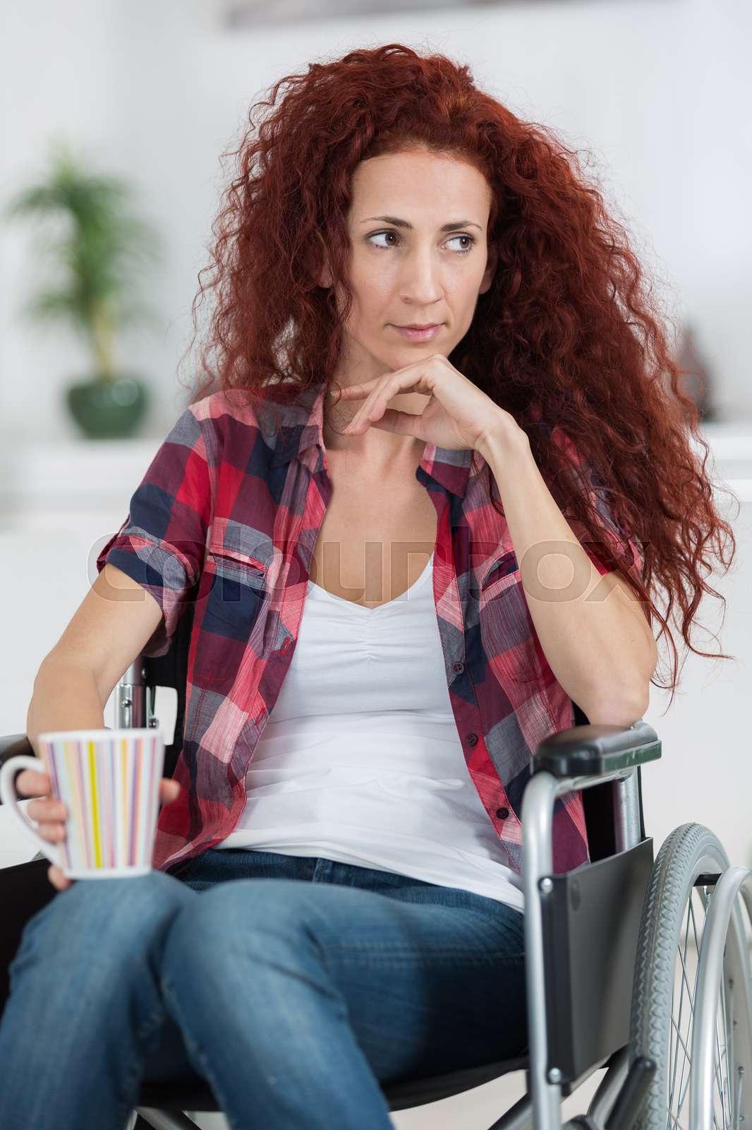 disabled woman with tea looking out a window | Stock image | Colourbox