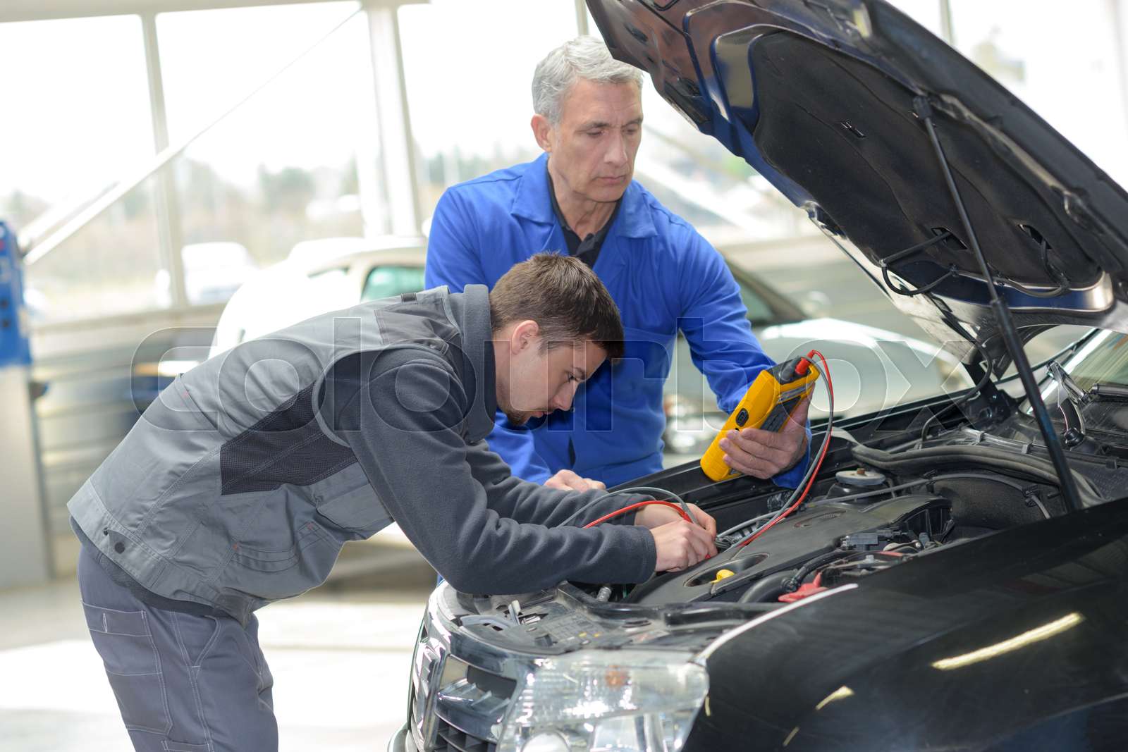 auto mechanic teacher and trainee performing tests at mechanic school ...