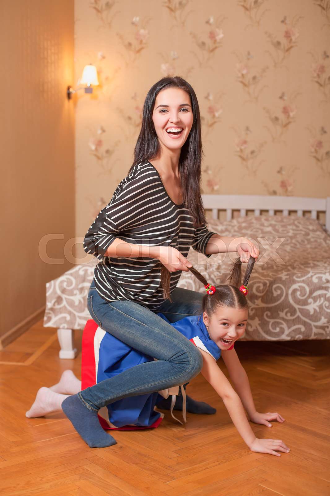 Mother and little girl playing a horse. | Stock image | Colourbox