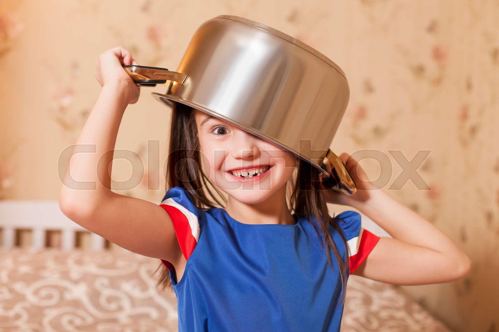 Kid fool around with pan on head. | Stock image | Colourbox