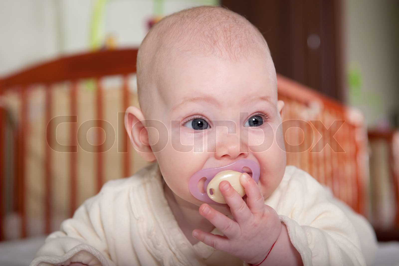 Grædende baby pige liggende på hvidt håndklæde | Stock foto | Colourbox
