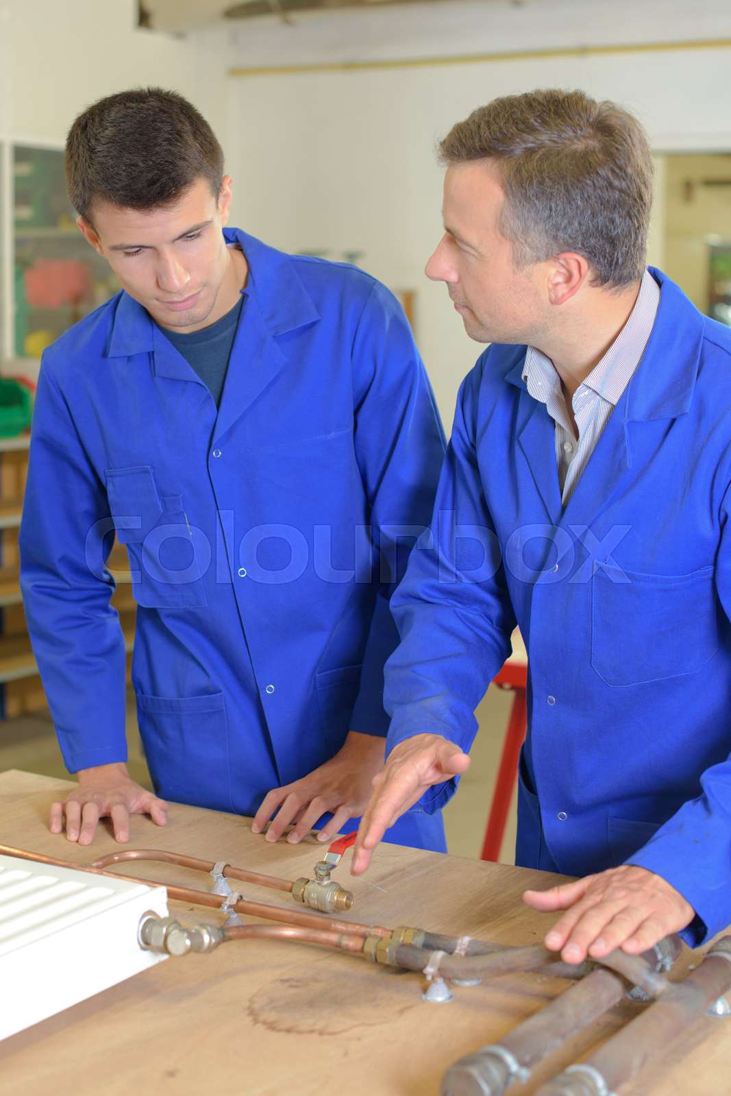 Plumber explaining to student | Stock image | Colourbox