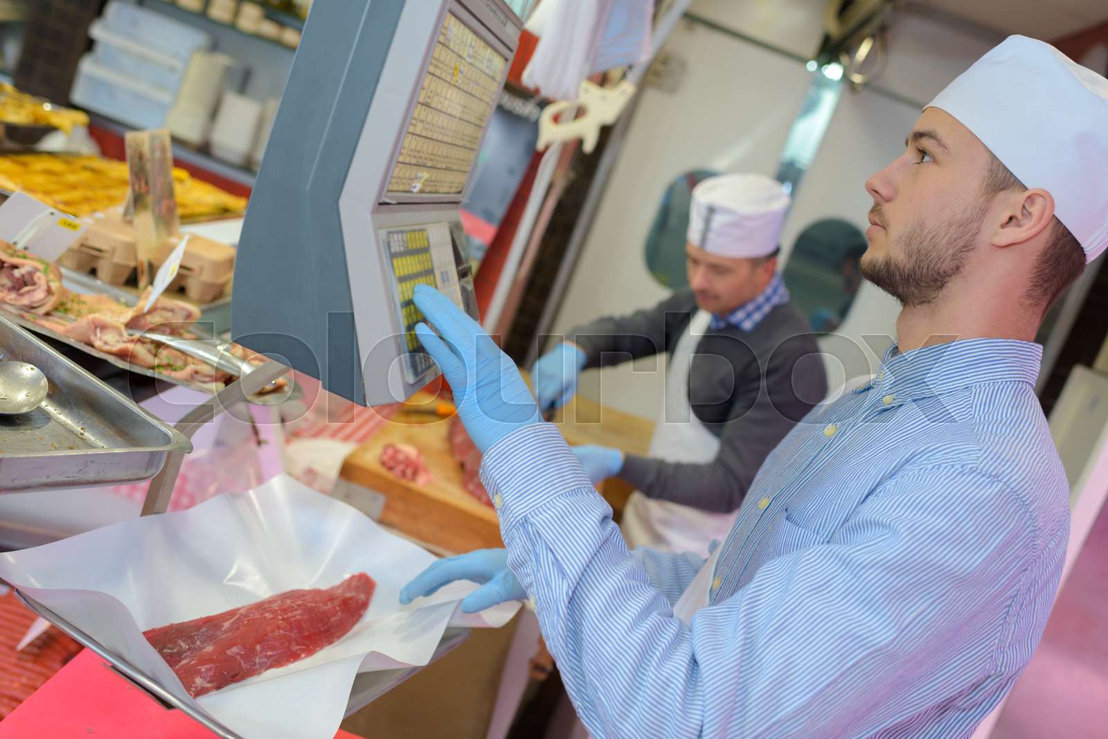 Butcher weighing meat | Stock image | Colourbox