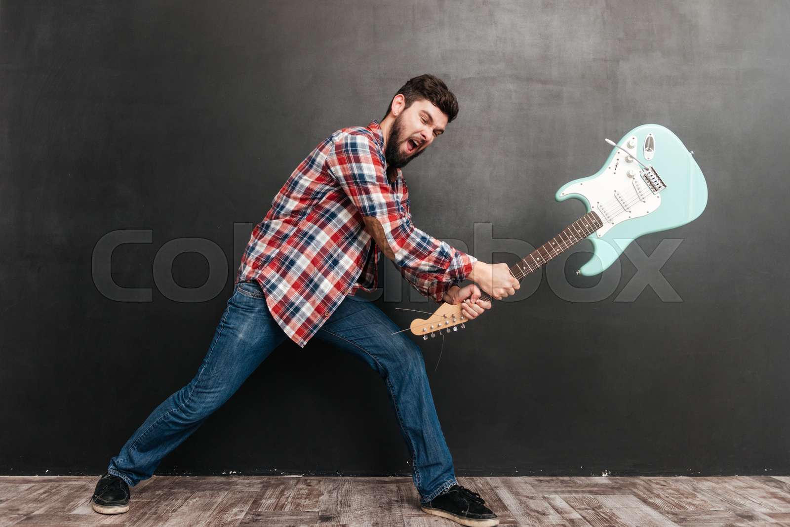 Agressive man breaks the guitar | Stock image | Colourbox