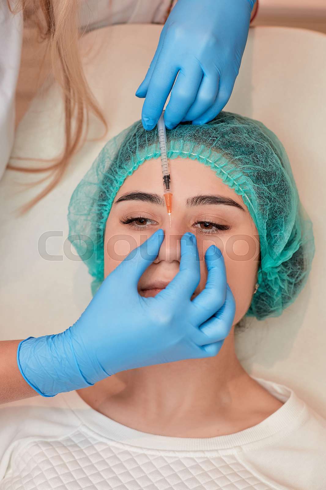 Woman receiving cosmetic injection through nose. | Stock image | Colourbox