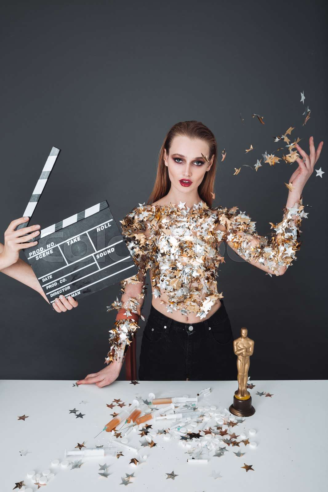 Woman actress throwing sparkles standing near the table with drugs ...