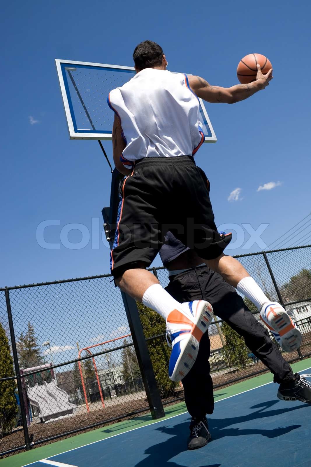 A young basketball player driving to the hoop with some fancy moves ...