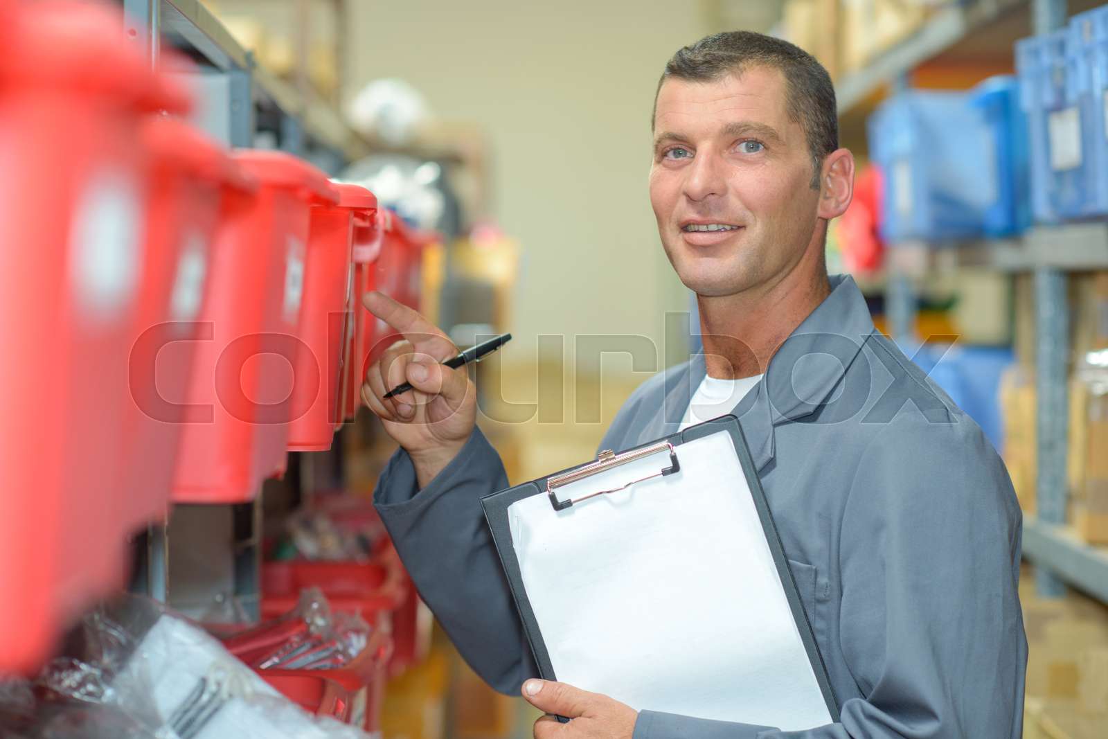 Man in warehouse pointing to container | Stock image | Colourbox