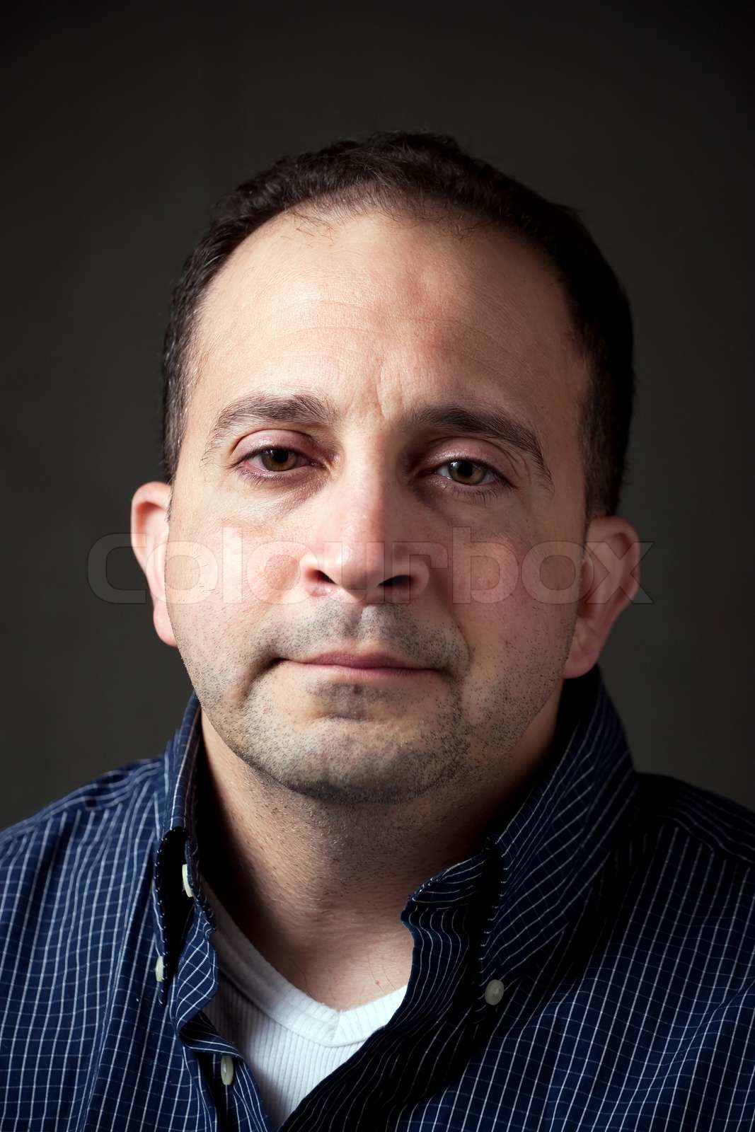 Portrait of a middle aged man in his upper thirties with a serious or ...