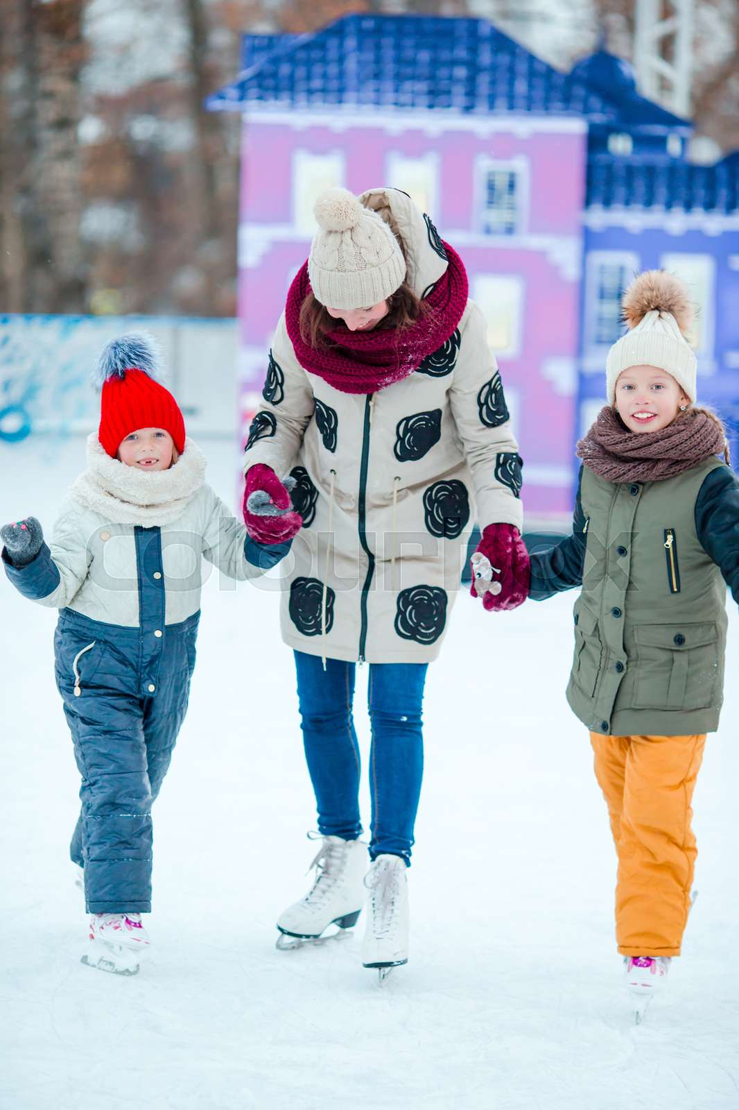 Family skating on ice-rink. Mother and kids learning to skate at winter ...