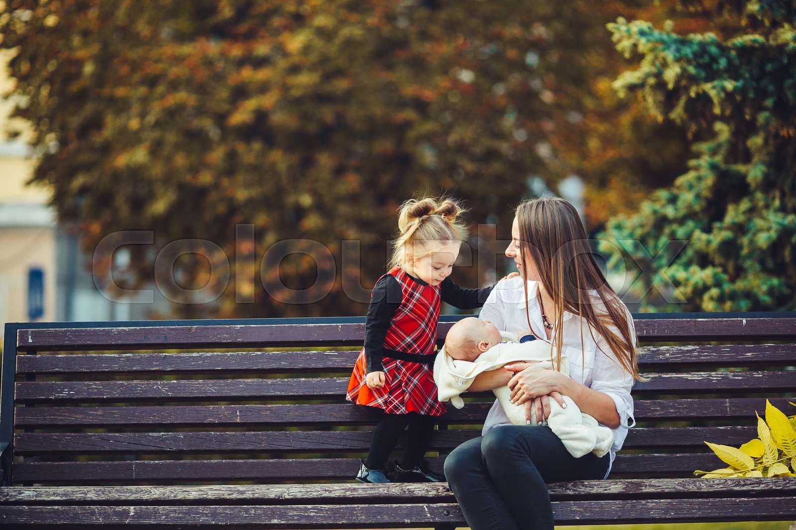 mother and two daughters rest on a bench | Stock image | Colourbox
