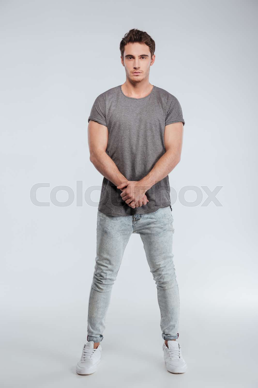 Confident attractive young man standing and looking camera | Stock ...