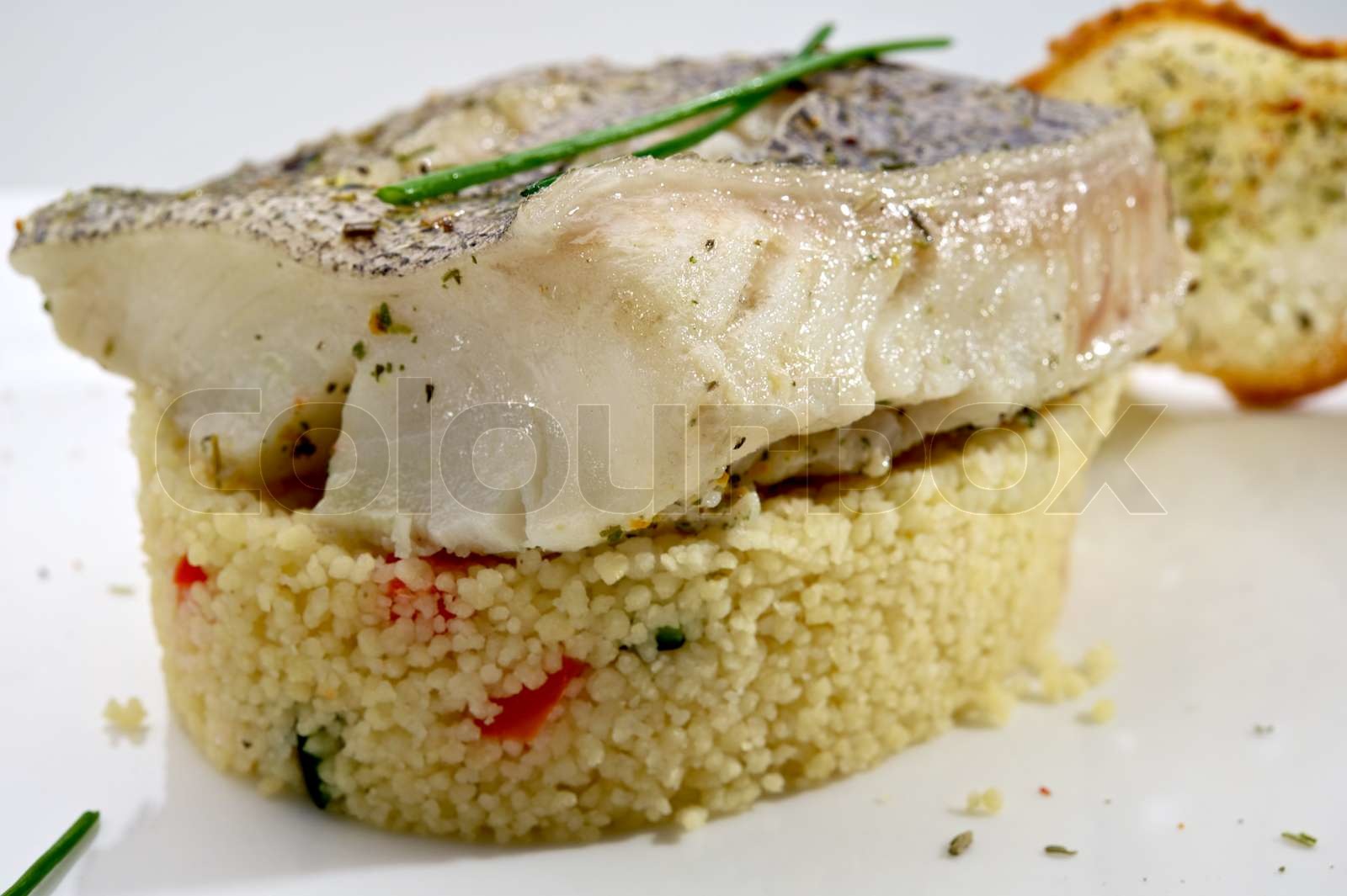 Pike-perch fillet garnished with vegetables and toast, served on white ...