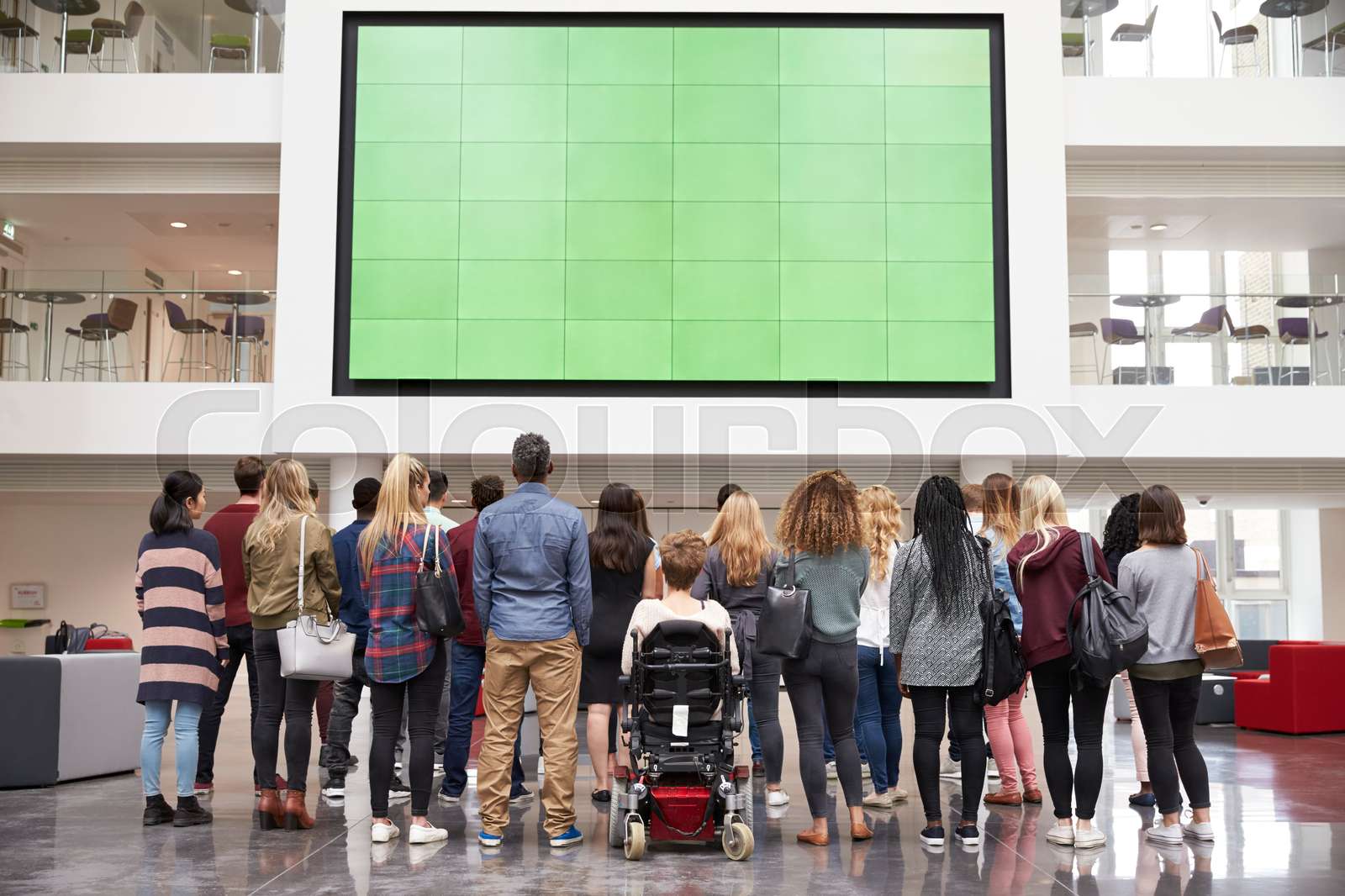 Students looking up at a big screen in university atrium | Stock image ...