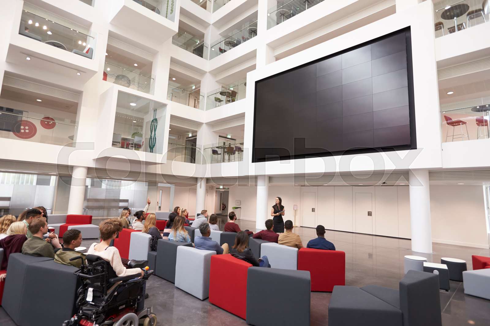 Students at a lecture in the atrium of a modern university | Stock ...