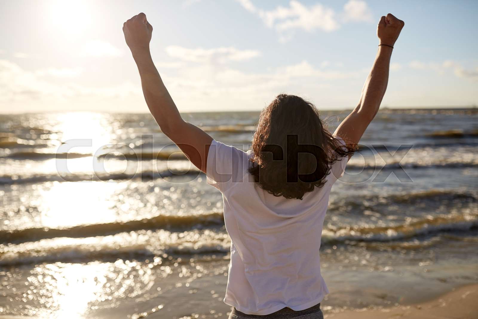 man with rised fist on beach | Stock image | Colourbox