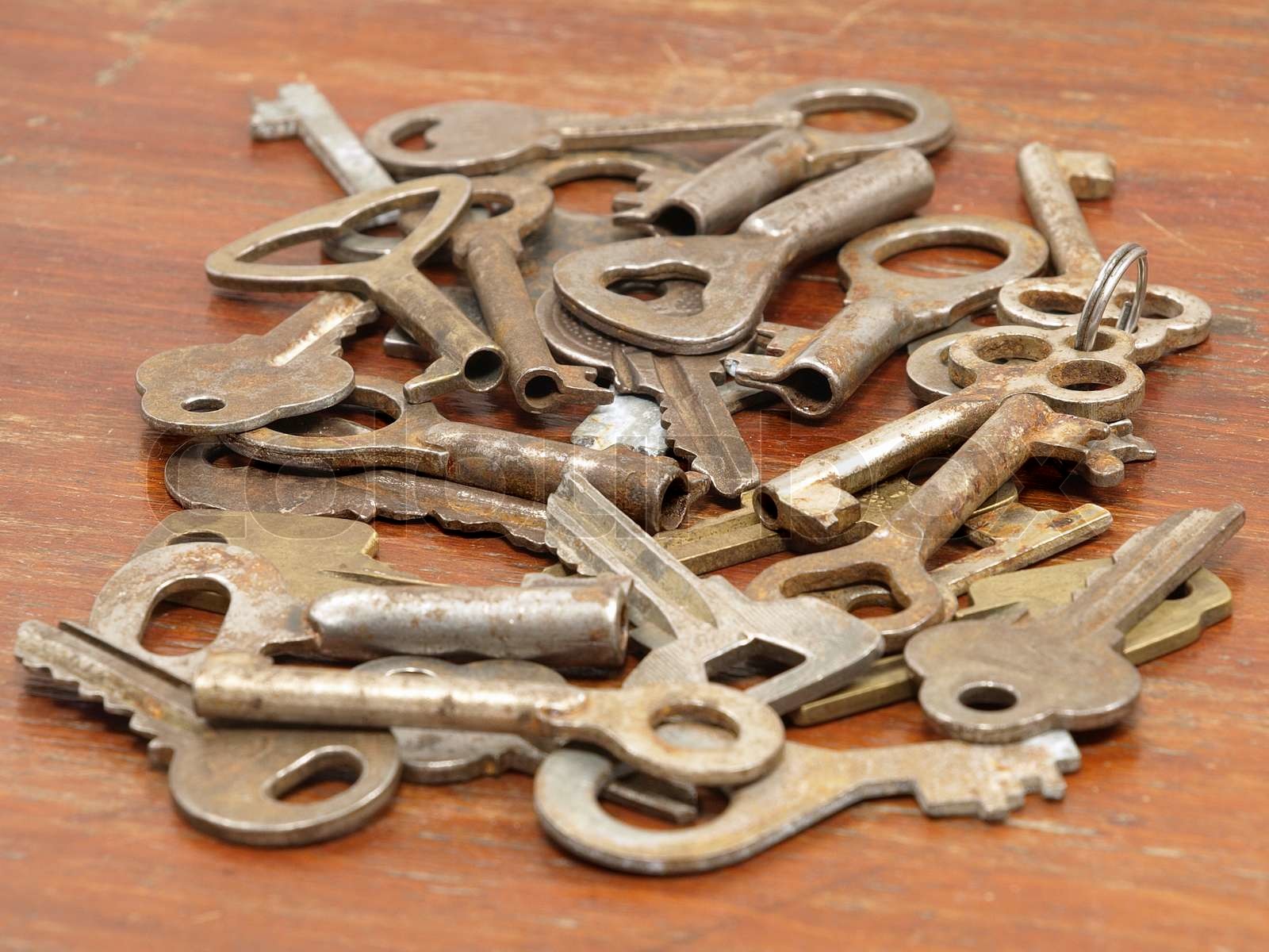 A lot of metal keys on a wooden surface closeup | Stock image | Colourbox