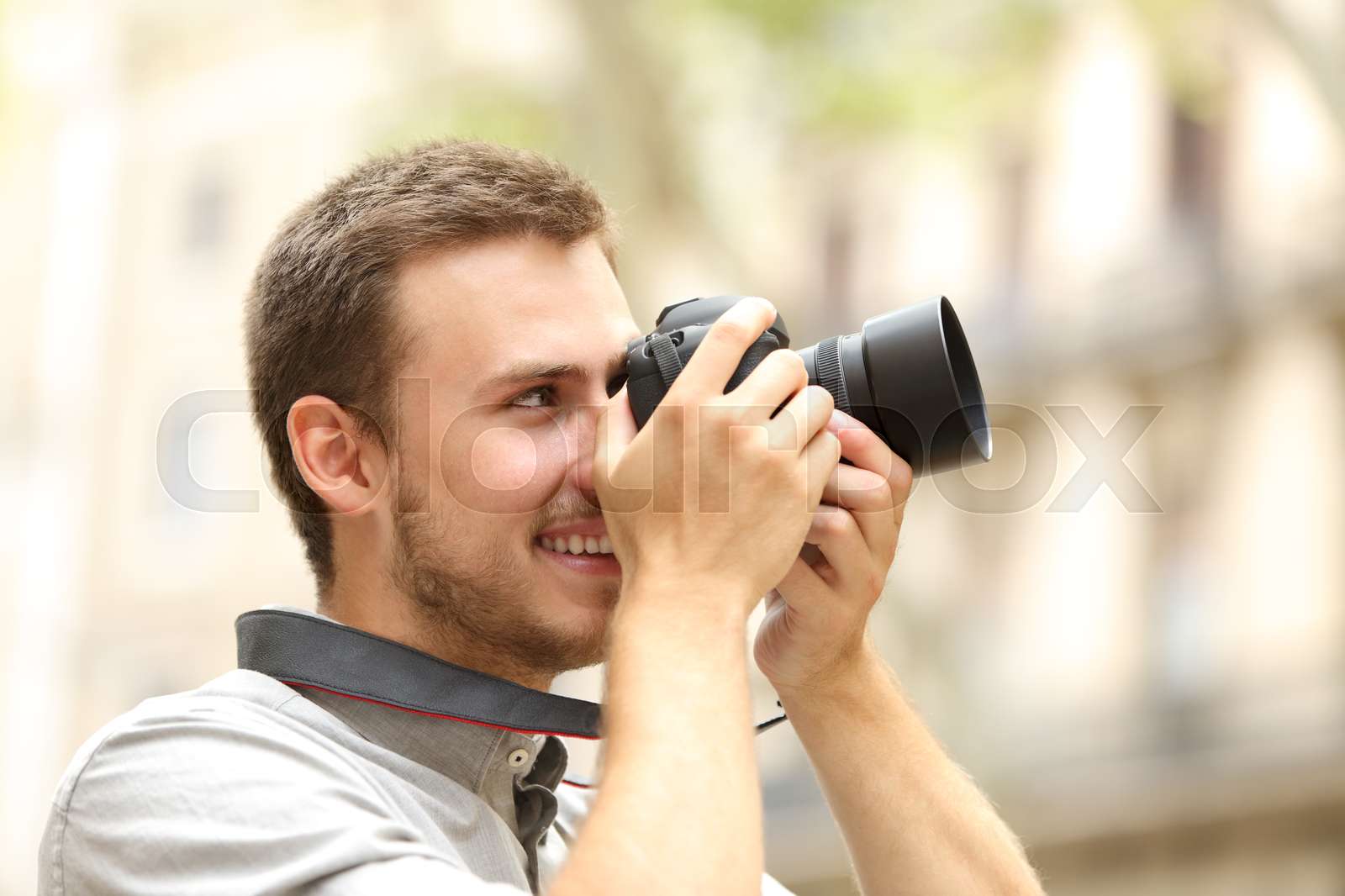 Man photographing with a camera in the street | Stock image | Colourbox