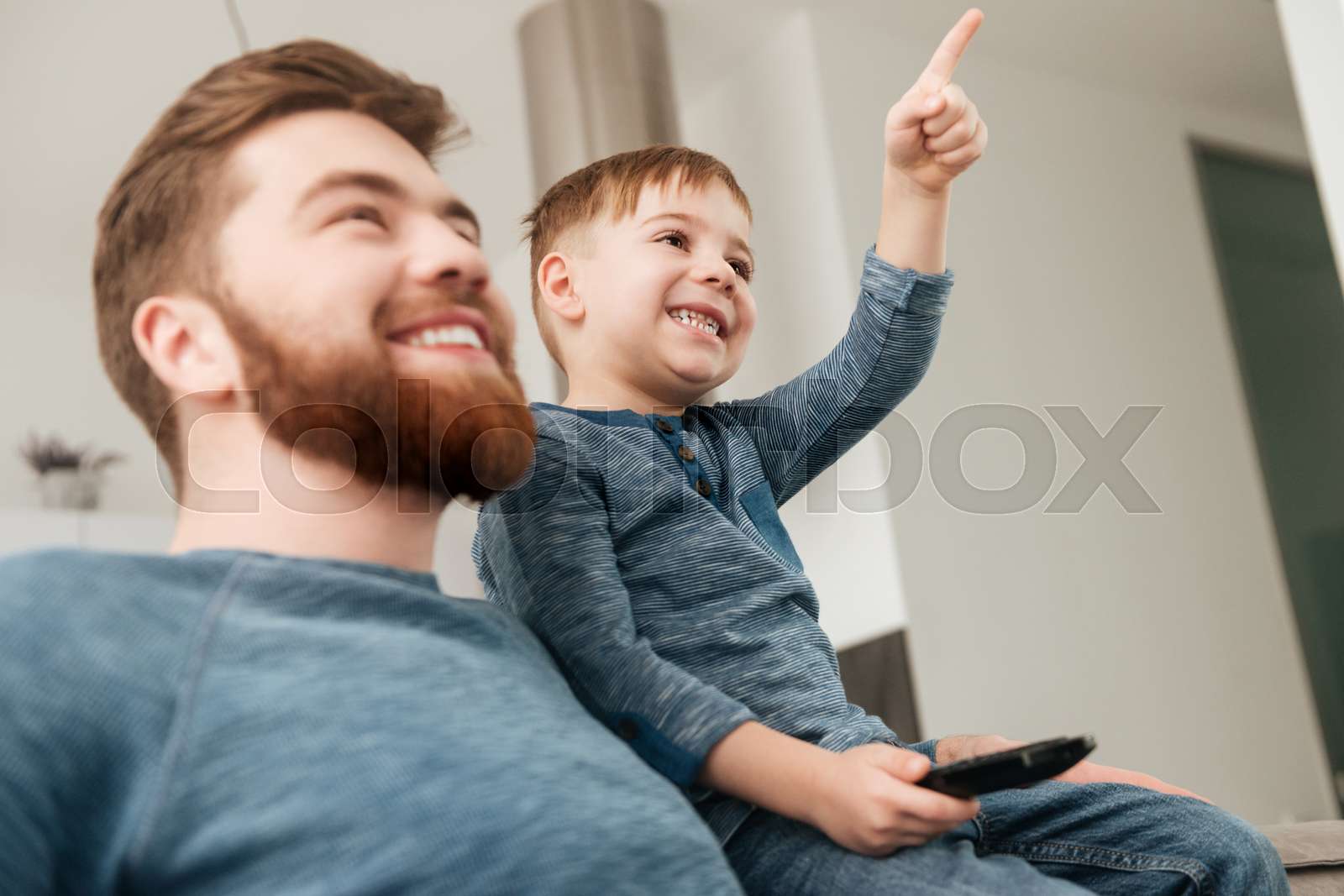 Happy father watching TV with his little cute son | Stock image | Colourbox