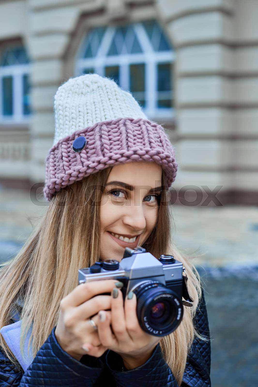 Beautiful girl photographer photographing the old town with retro ...