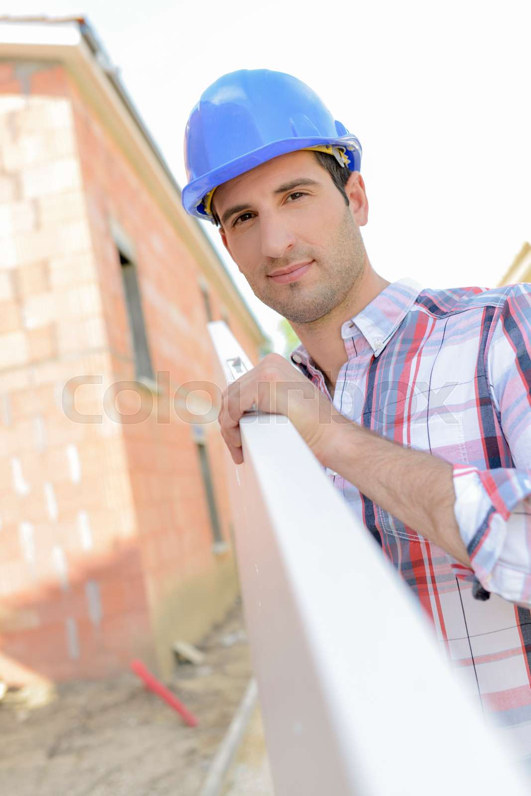 Construction worker carrying a planl | Stock image | Colourbox