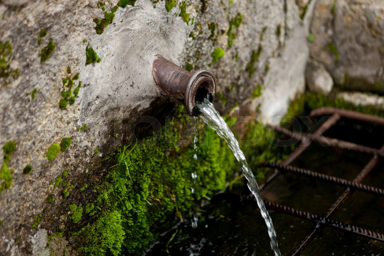 Pipe clean water pouring from a natural source | Stock image | Colourbox