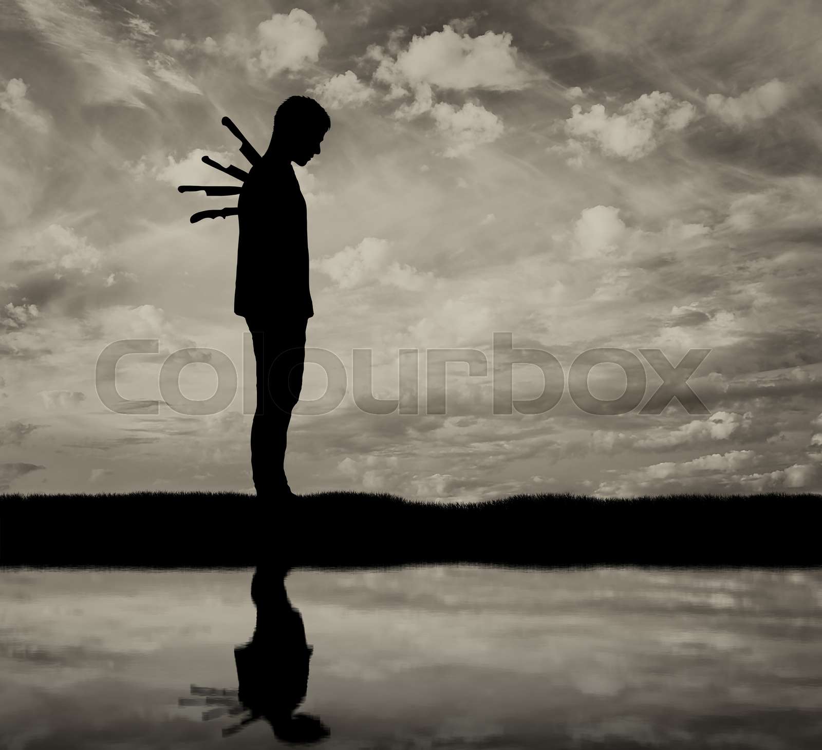 Silhouette of a sad man with a knives in the back | Stock image | Colourbox