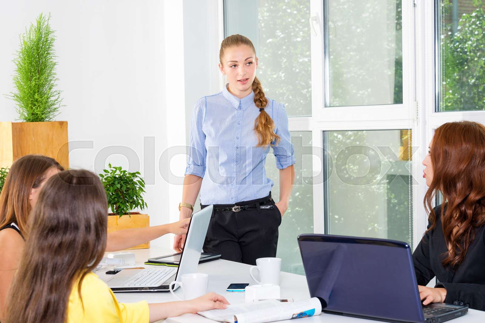 Pretty young business woman giving a presentation in conference or ...