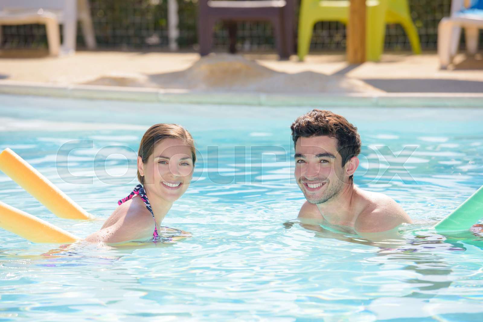 Couple in swimming pool using floats | Stock image | Colourbox