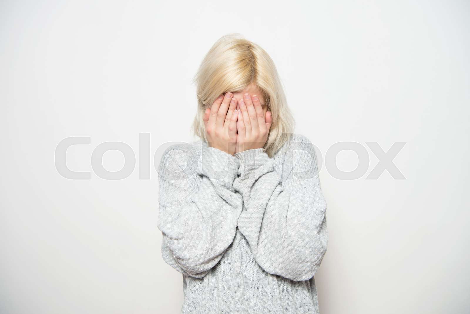Woman covers his face by hand | Stock image | Colourbox