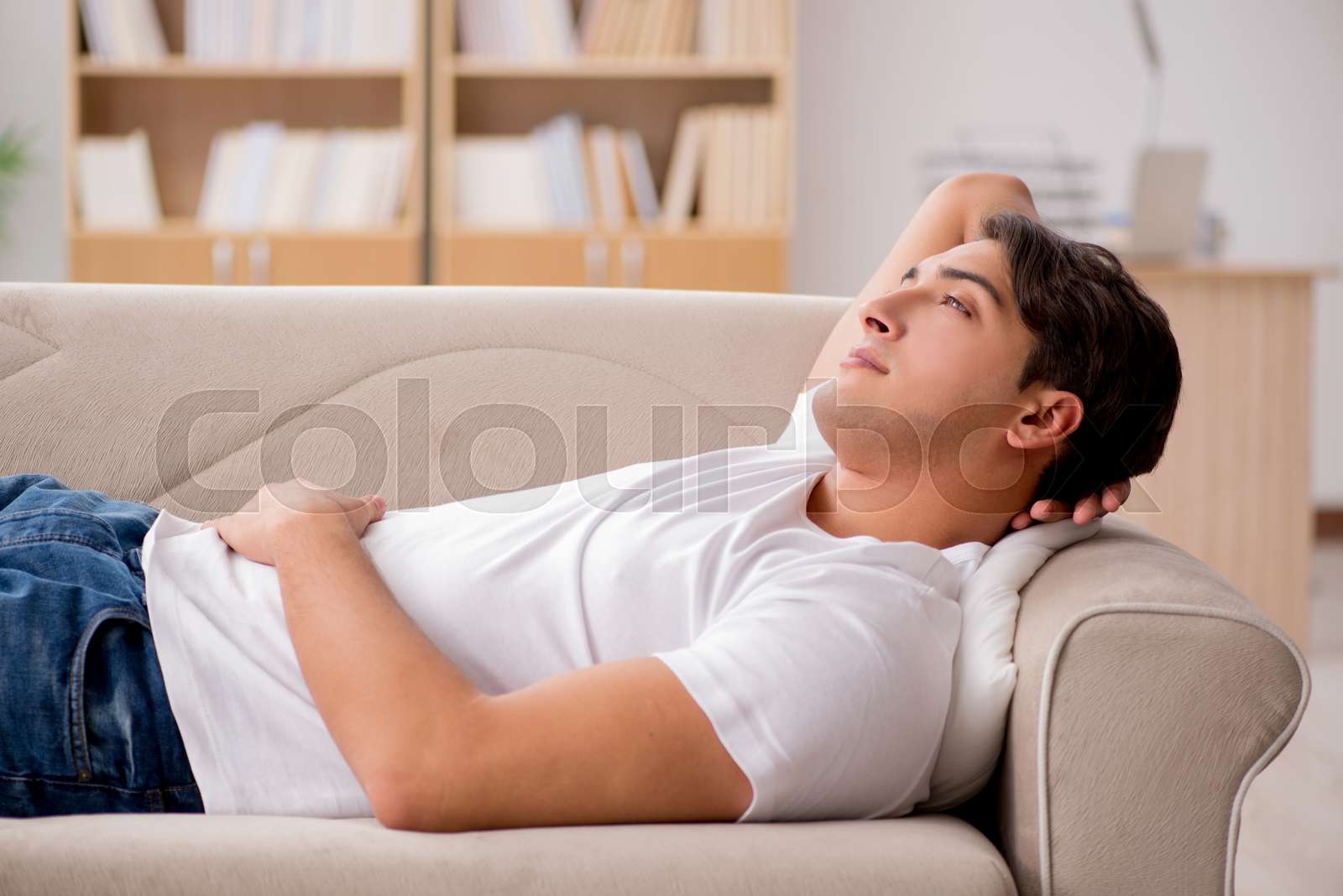 Young man sleeping in sofa couch | Stock image | Colourbox