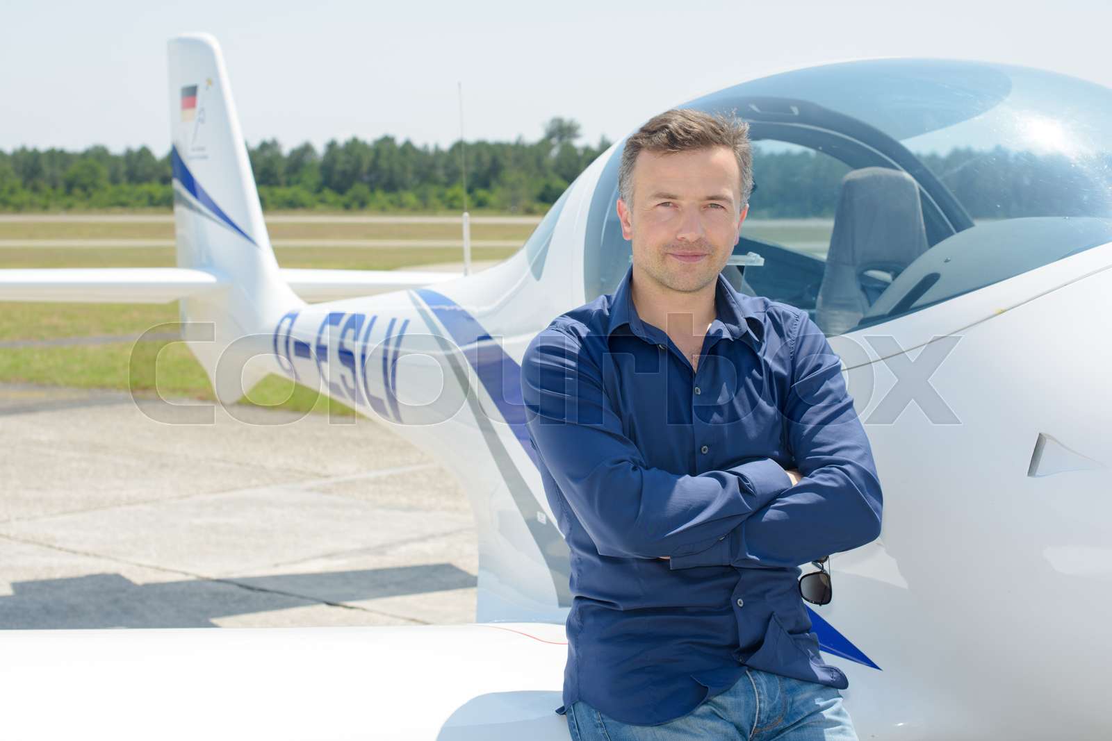 Portrait of man sitting on wing of aircraft | Stock image | Colourbox