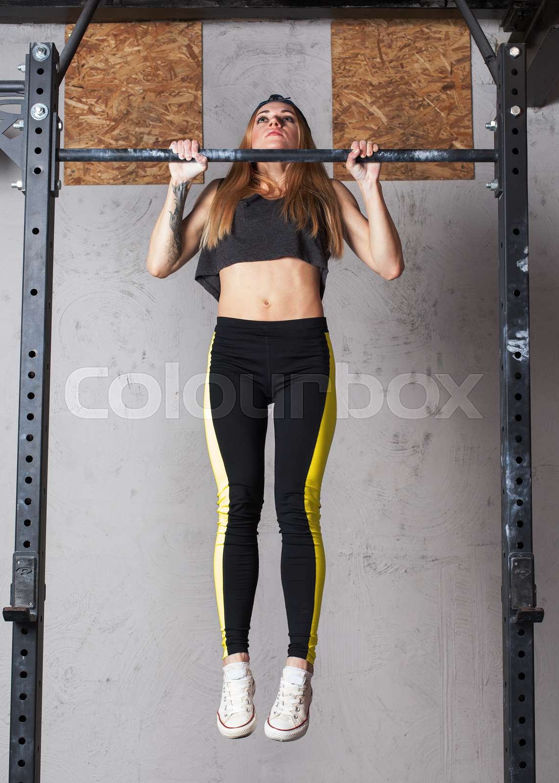Woman athlete doing pull-ups | Stock image | Colourbox