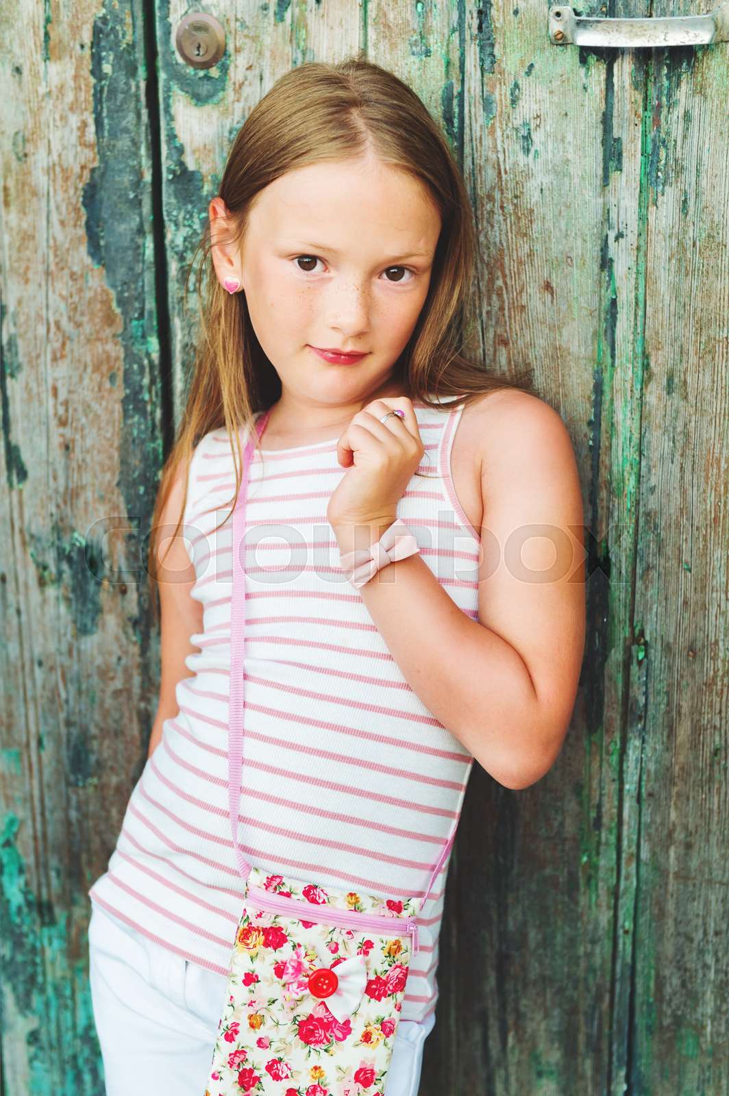 Vertical portrait of a cute little 7-8 year old girl wearing many ...