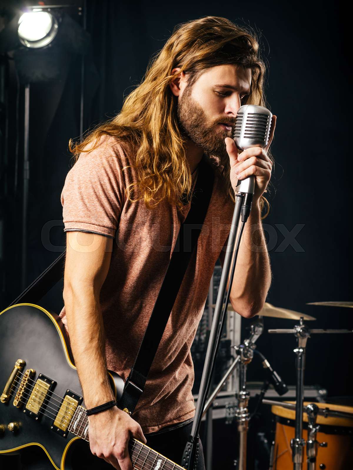 Young man singing and playing electric guitar on stage | Stock image ...