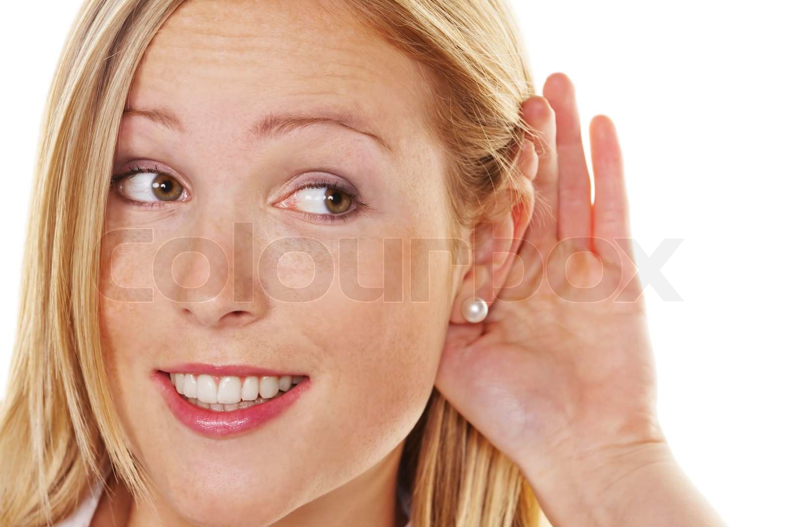 A young woman holds the hand behind the ear to listen | Stock image ...