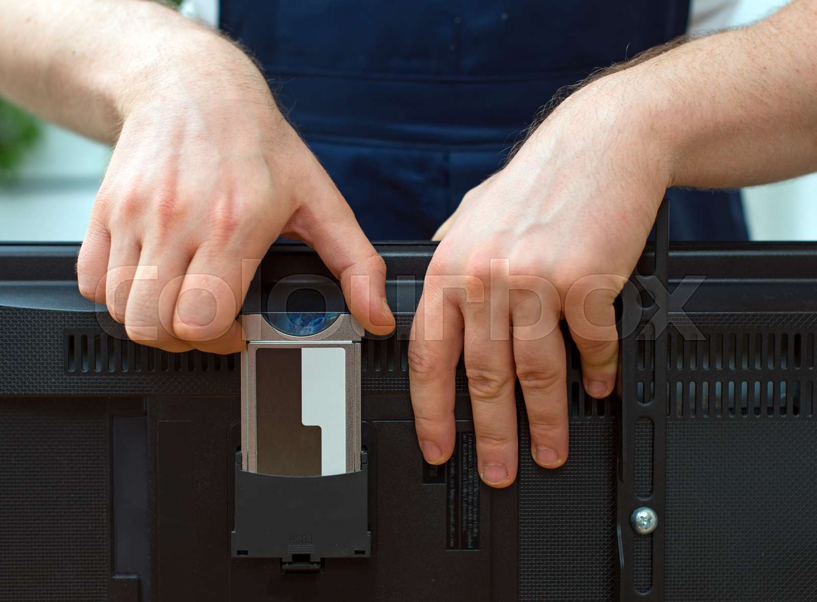 Man installing conditional access module card to TV. | Stock image ...