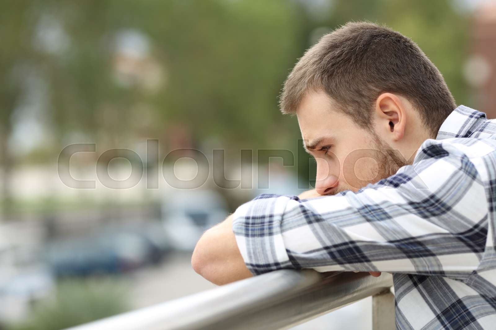 Sad man looking down from a balcony | Stock image | Colourbox