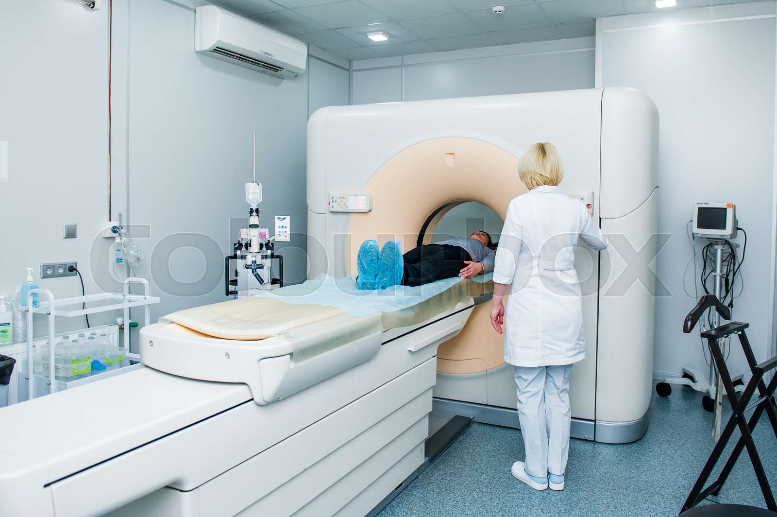 Female doctor adjusts computed tomography or computed axial tomography ...