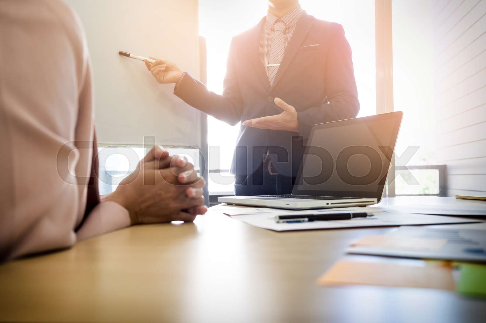 Businesswoman asking question during her colleagues presentation in ...