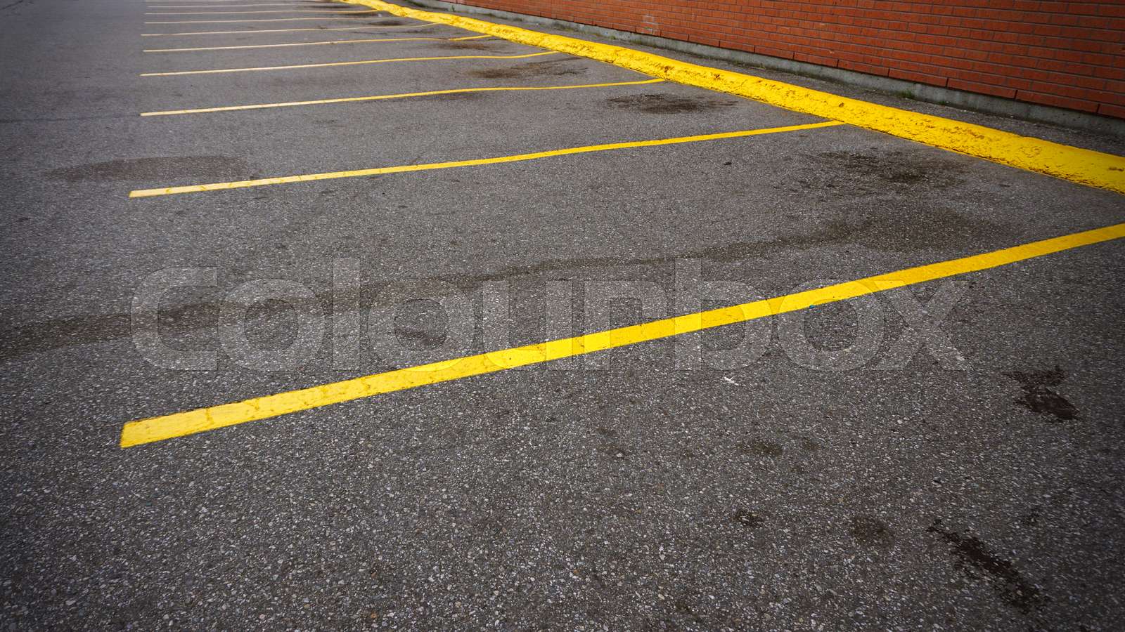 An empty parking spot with yellow lines beside the building | Stock ...