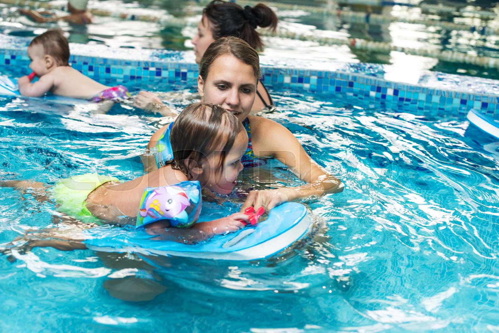 Young boy kid child eight years old splashing in swimming pool having ...